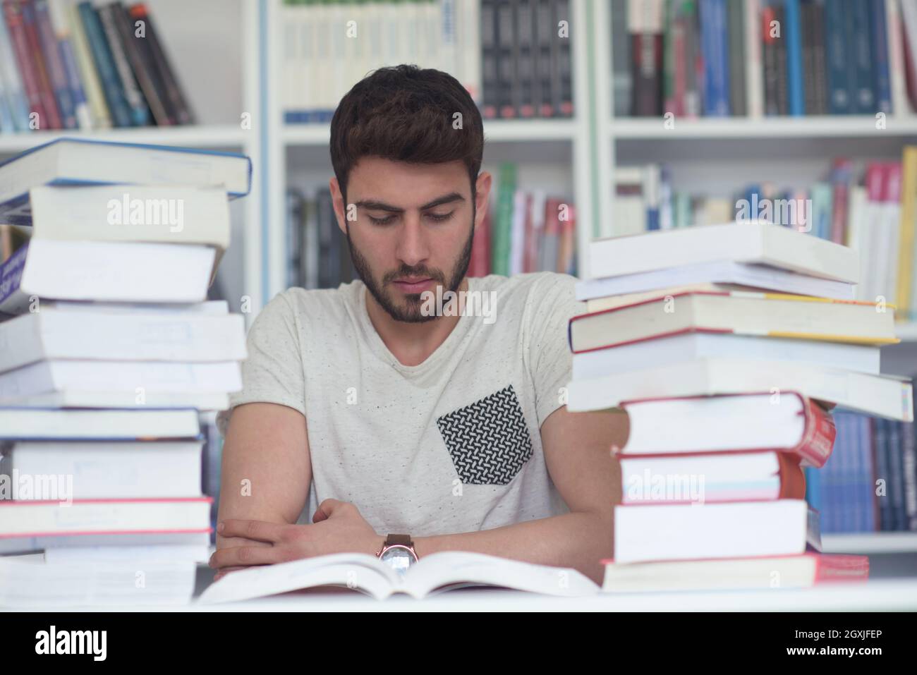 Student reading book in school library. Study lessons for exam. Hard ...