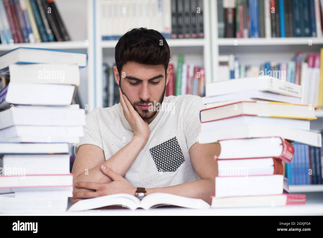 Student reading book in school library. Study lessons for exam. Hard ...