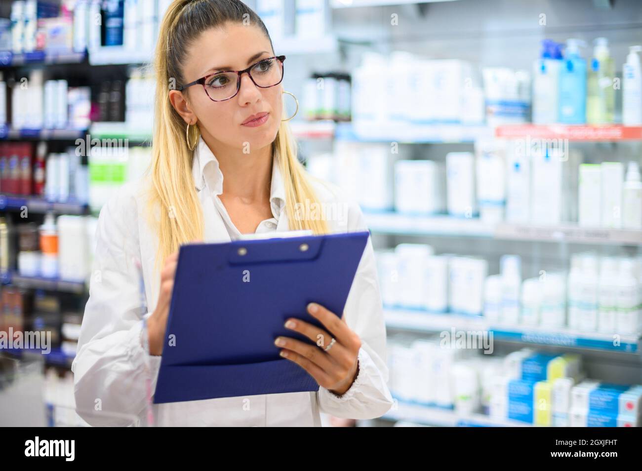 Female pharmacist checking wares in her store Stock Photo - Alamy