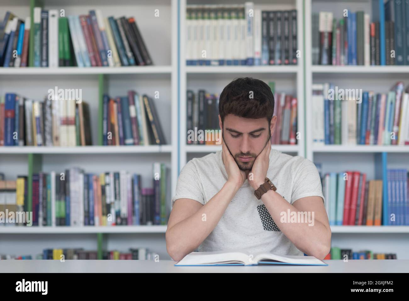 Student reading book in school library. Study lessons for exam. Hard ...