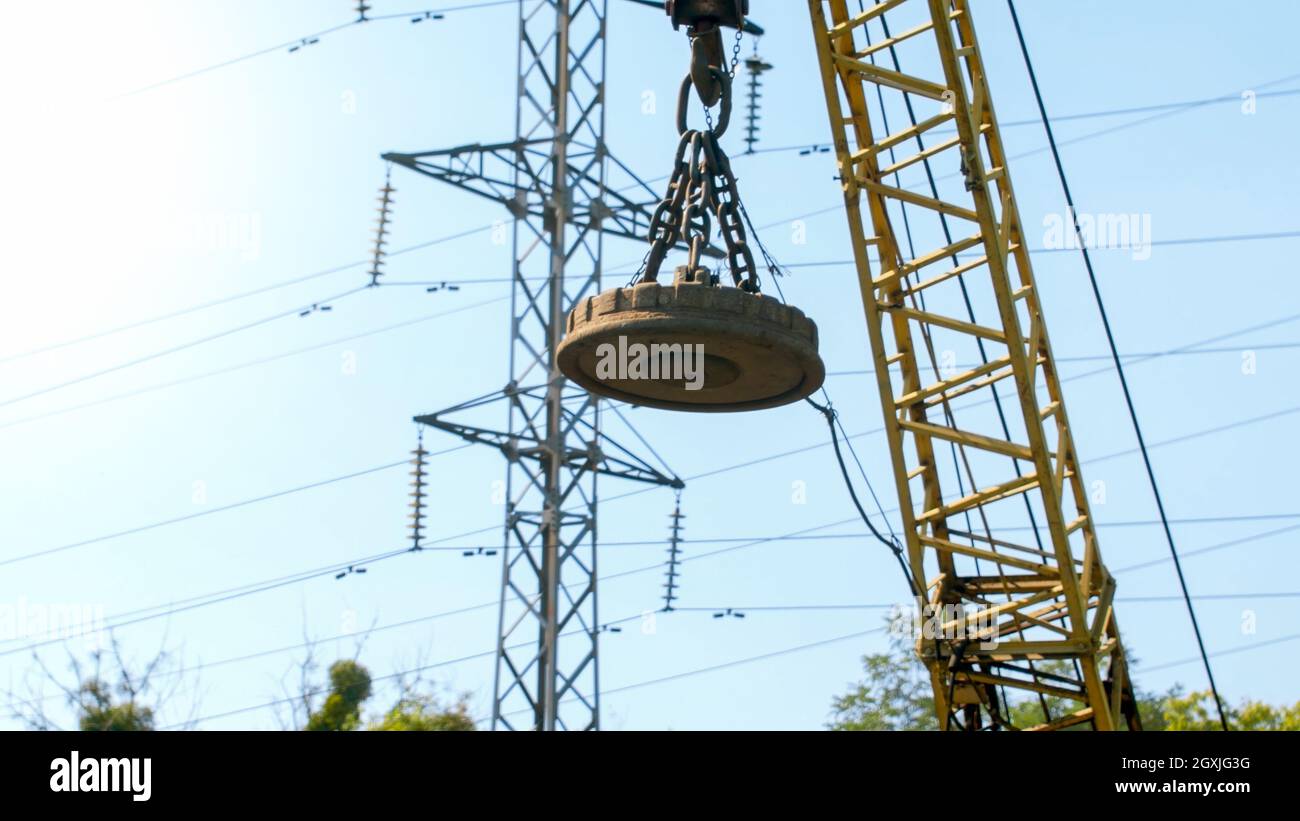 Photo of big electric magnet hanging on crane on the dump Stock Photo ...