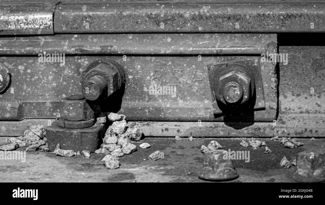 Black and white photo of old rusty connection between rails on railway ...