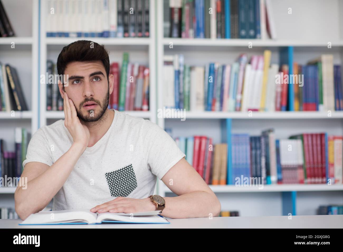 Student reading book in school library. Study lessons for exam. Hard ...