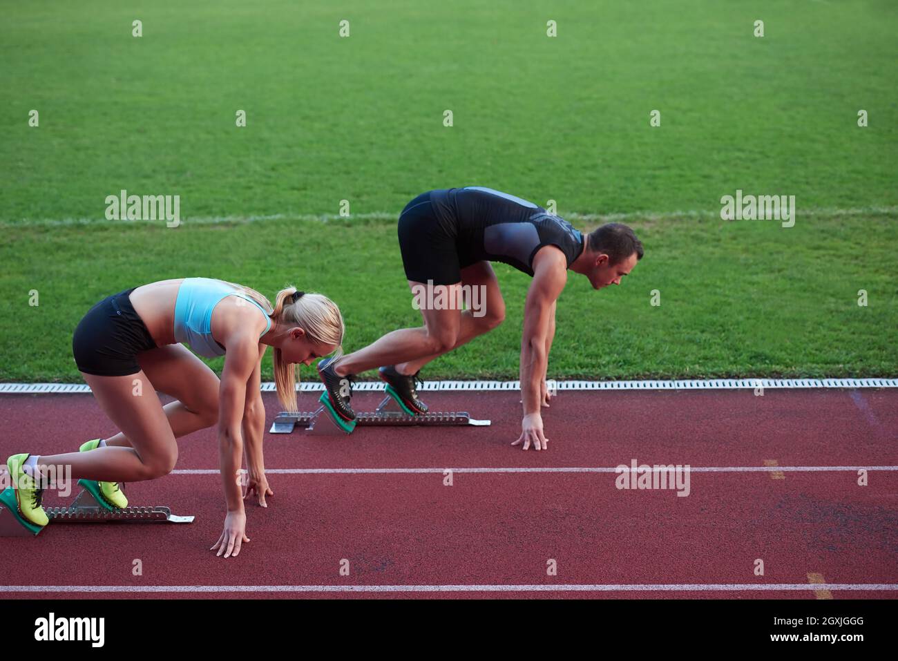 athlete woman group running on athletics race track on soccer stadium ...