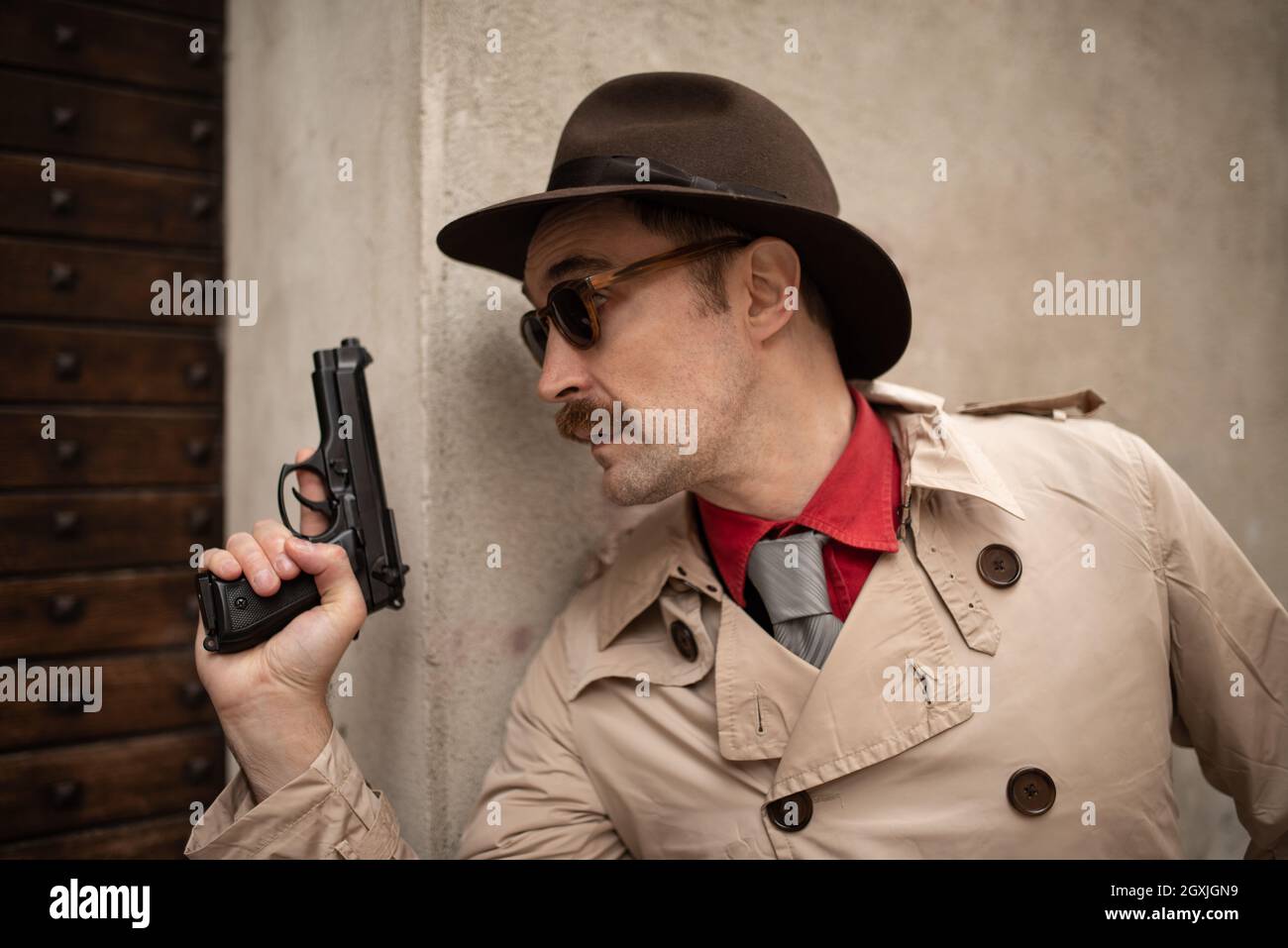Detective using his gun in a skid row Stock Photo - Alamy