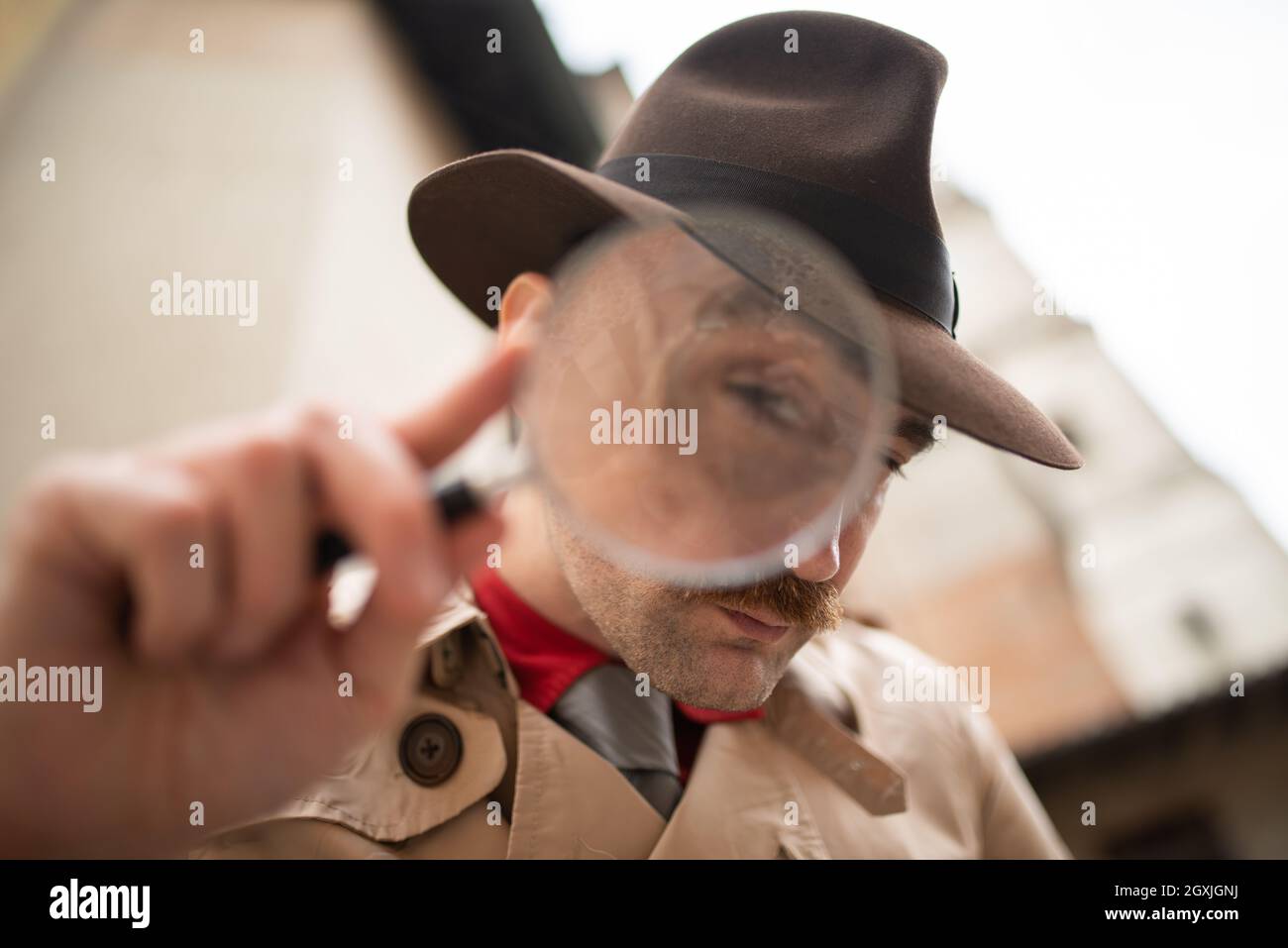 Vintage detective using a magnifying glass Stock Photo - Alamy