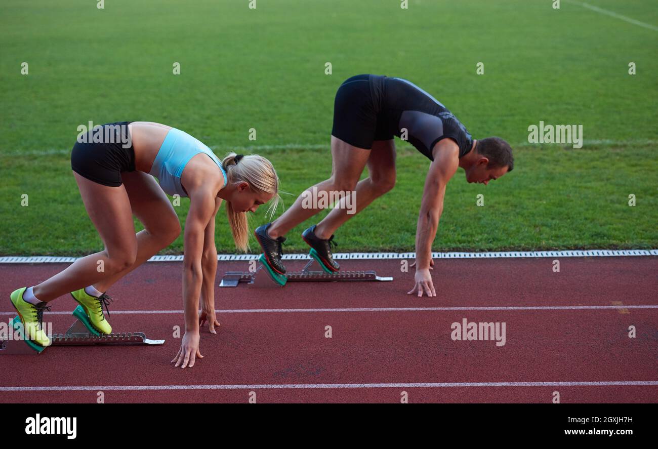 athlete woman group running on athletics race track on soccer stadium ...