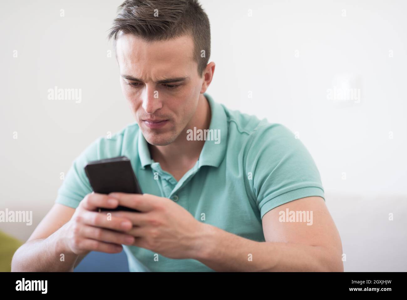 Handsome casual young man using a mobile phone at luxurious home Stock ...