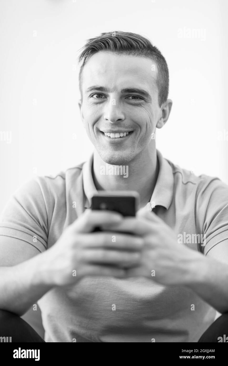 Handsome casual young man using a mobile phone at luxurious home Stock ...