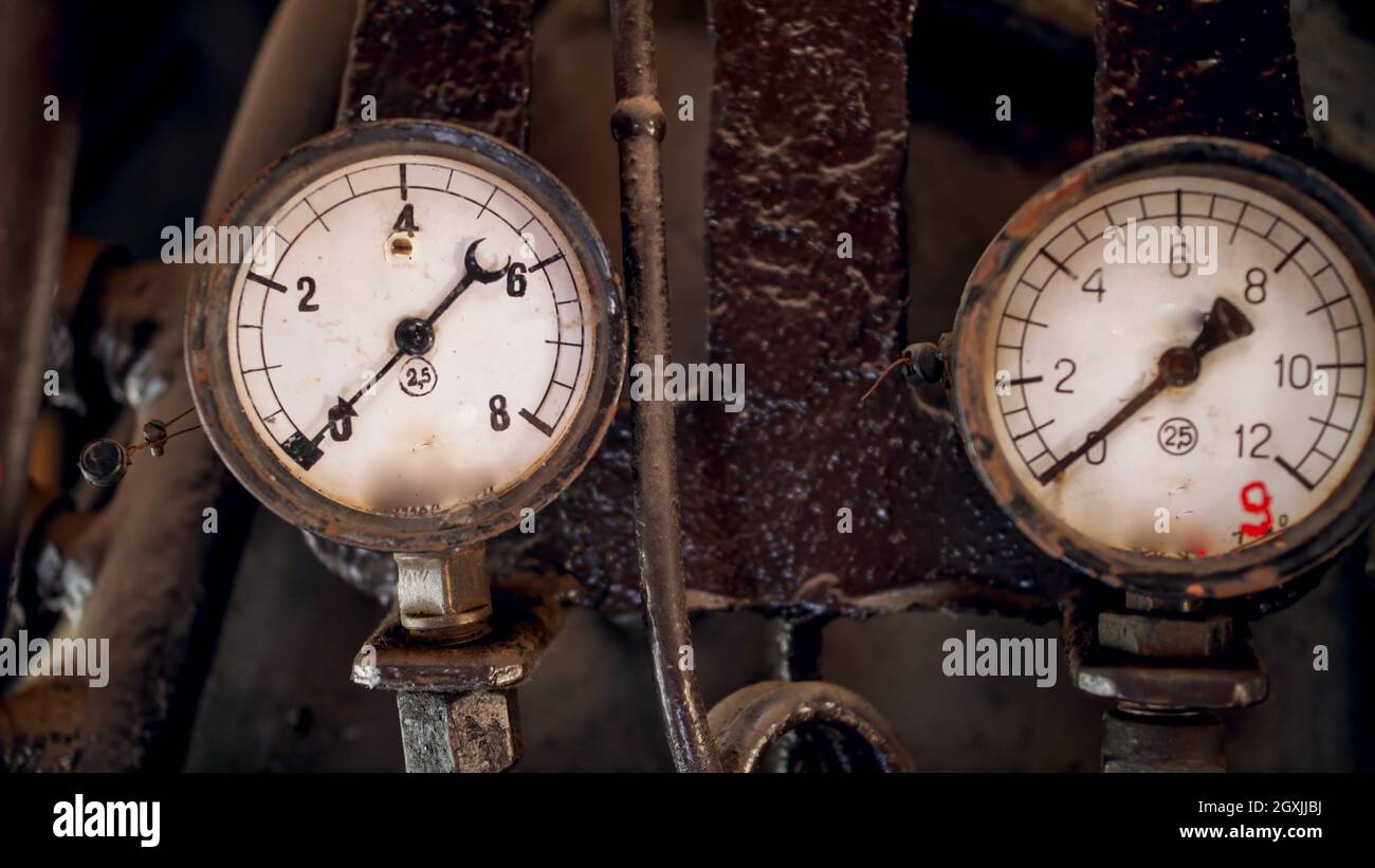 Closeup photo of two rusty manometers with analog dials connected to ...