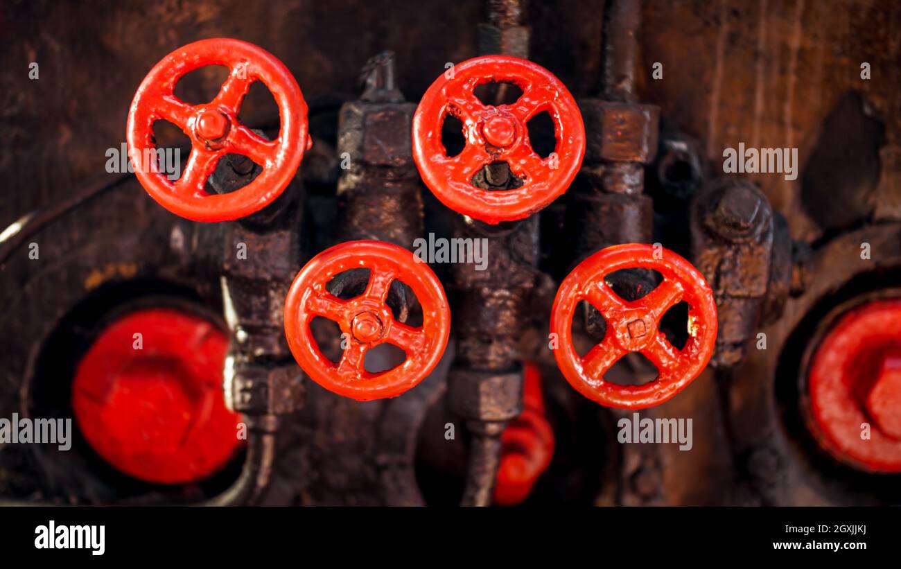 Closeup image of red painted vavles and black pipes of vintage high ...