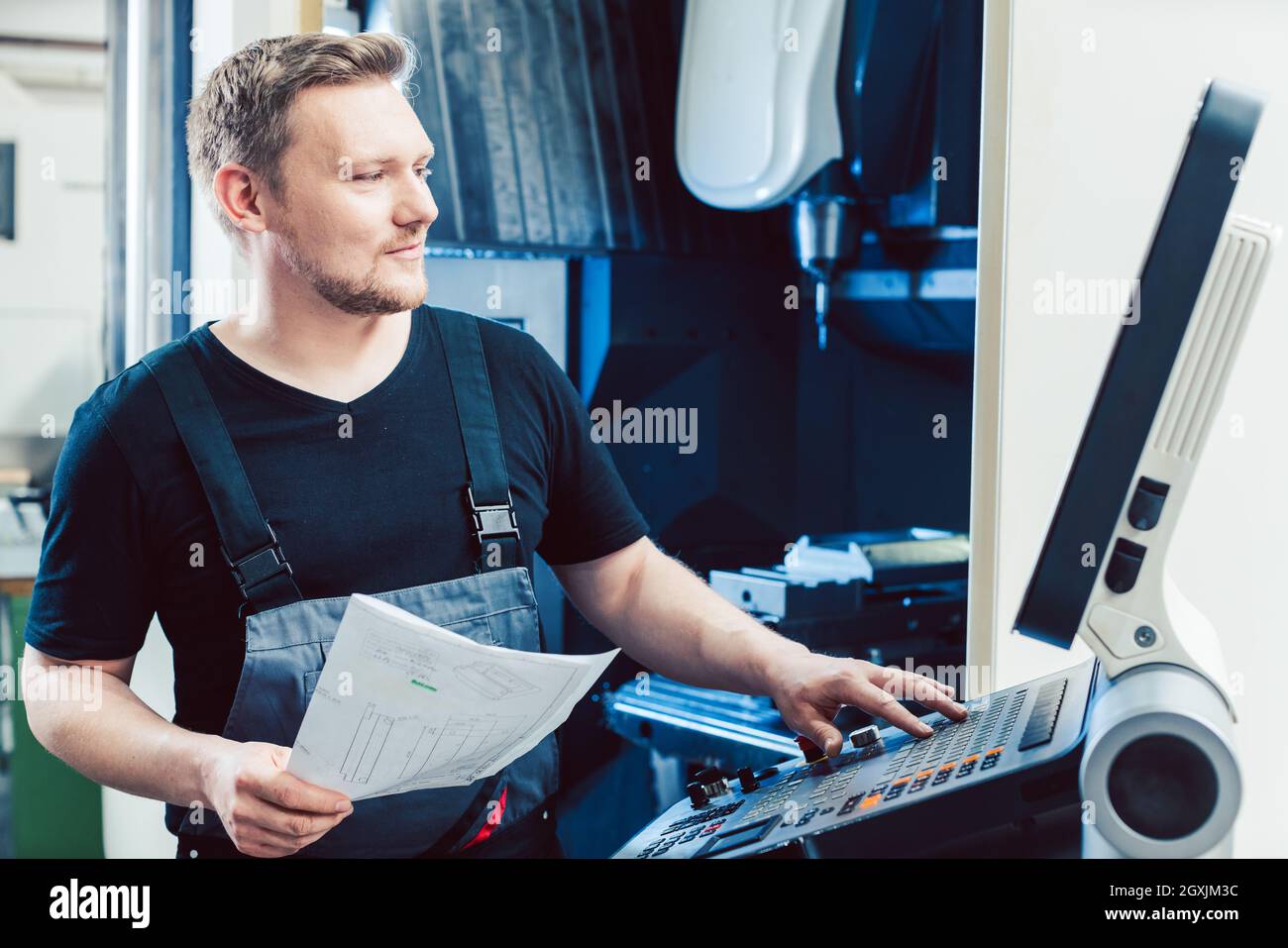 Young machine operator programming modern industrial cnc lathe Stock ...