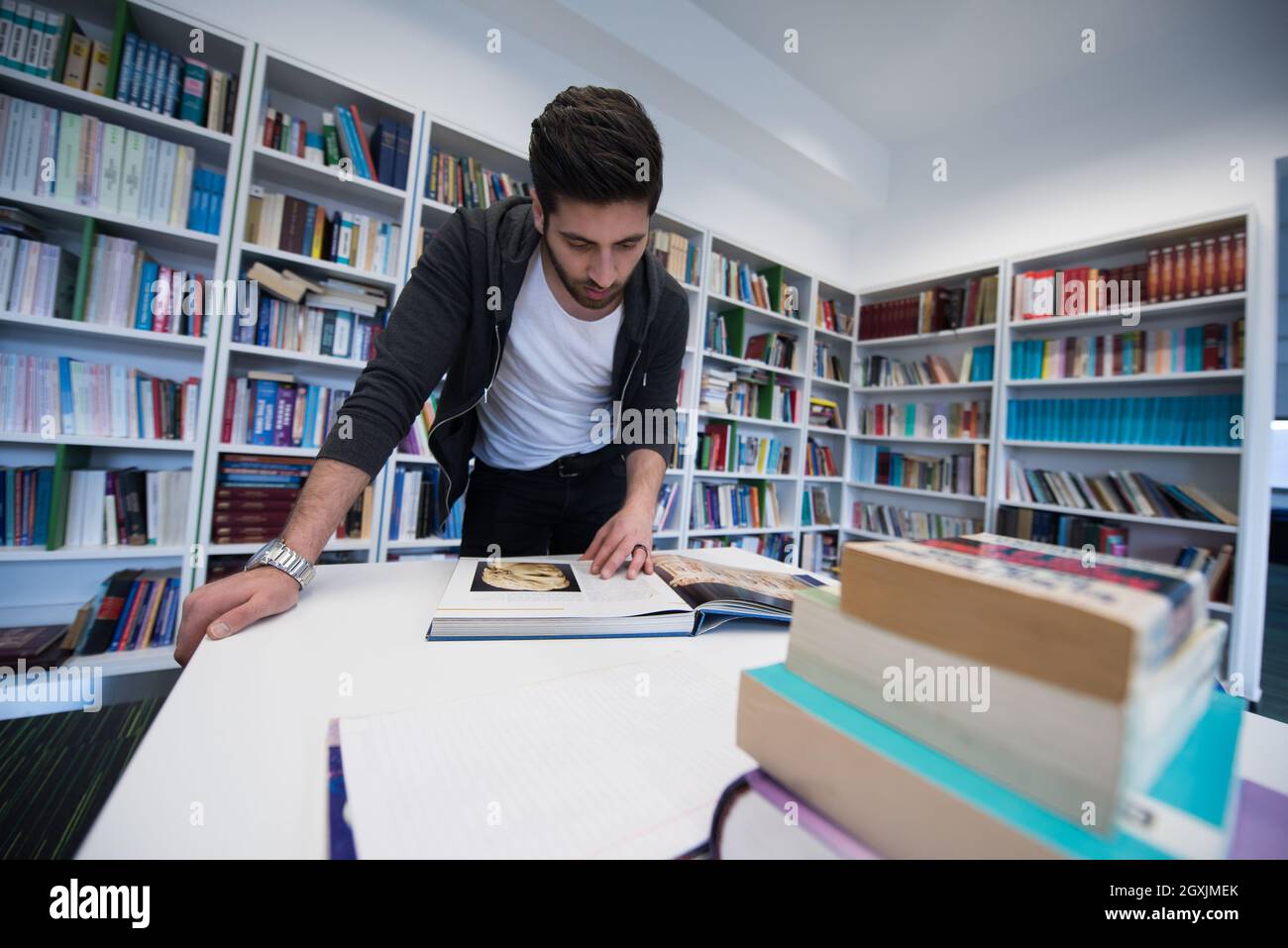 Student reading book in school library. Study lessons for exam. Hard ...
