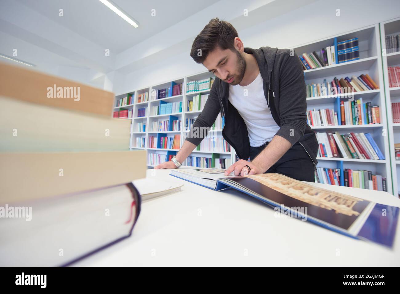 Student reading book in school library. Study lessons for exam. Hard ...
