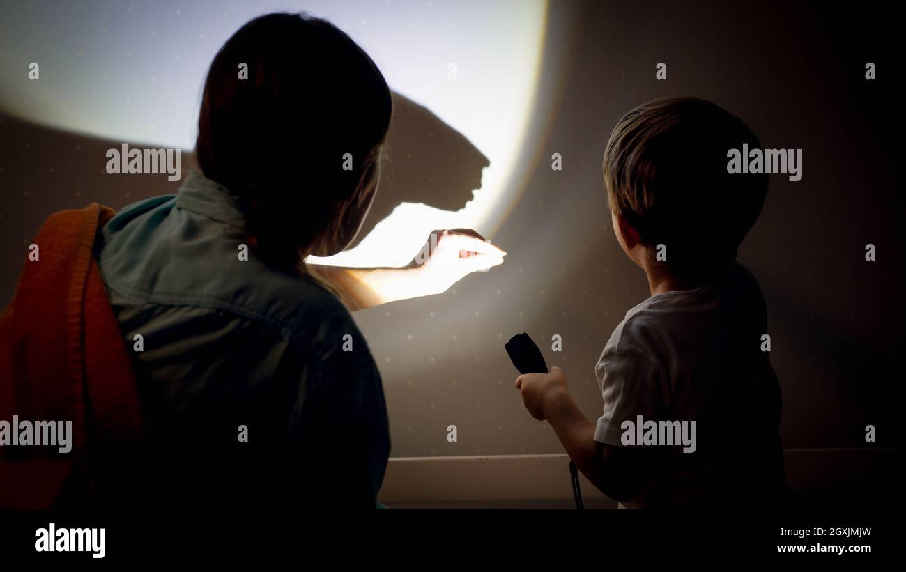 Closeup image of young mother teaching her little son showing shadows ...
