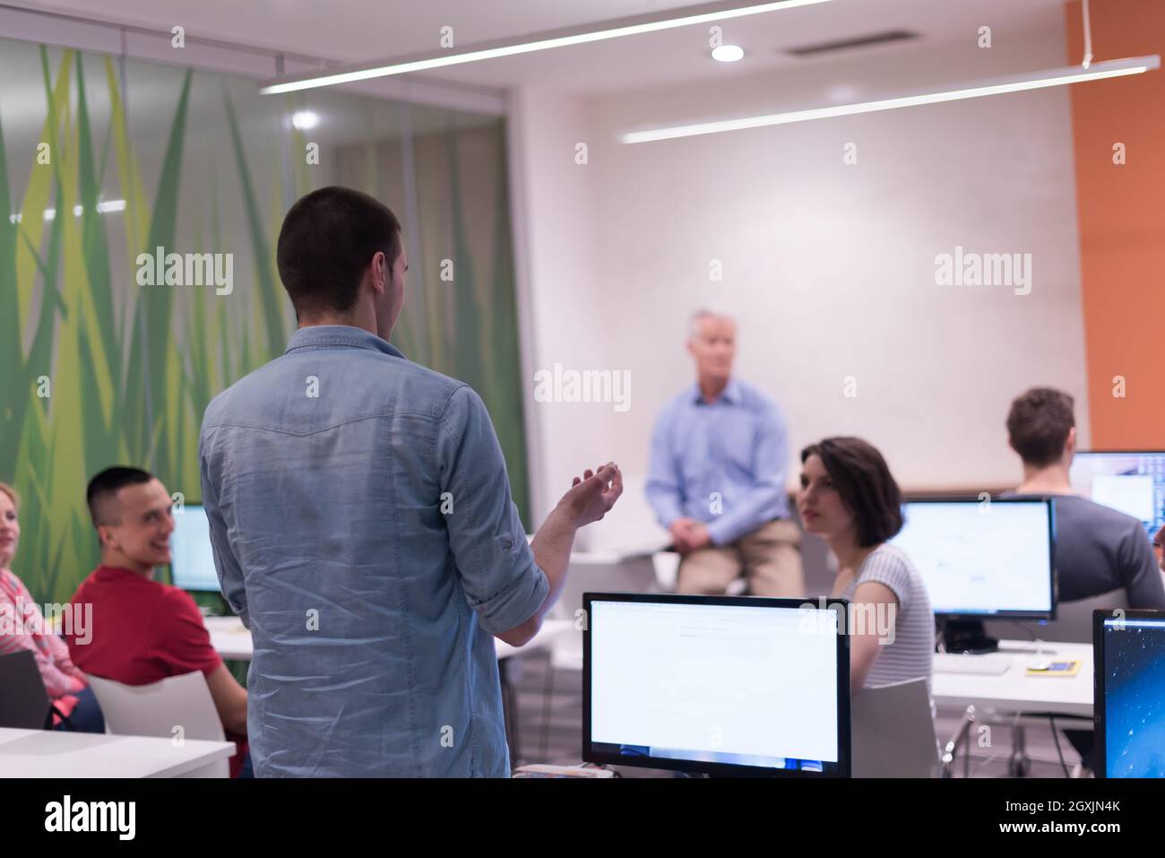 student answering a question in classroom, mature teacher and students ...