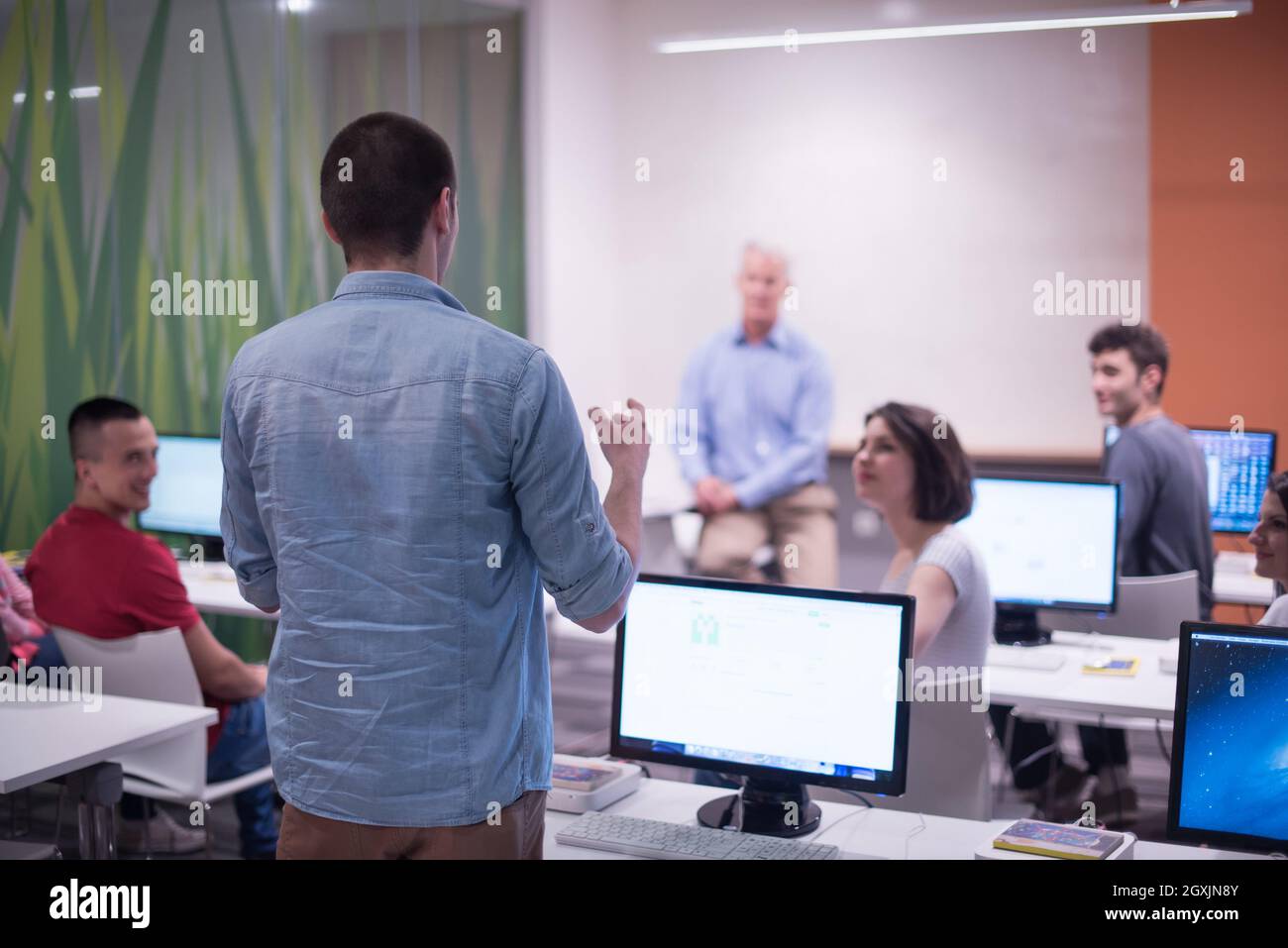 student answering a question in classroom, mature teacher and students ...