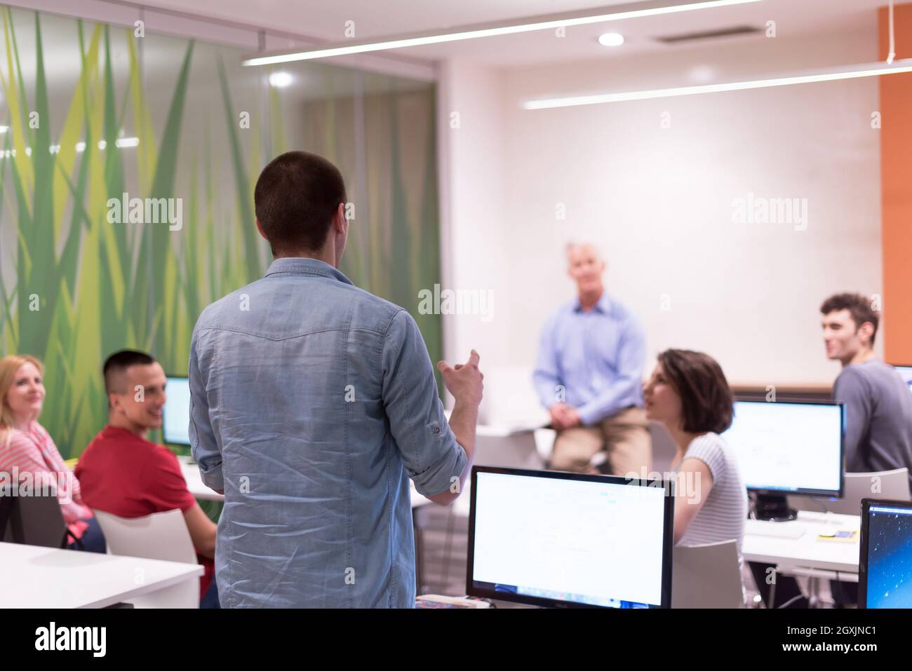student answering a question in classroom, mature teacher and students ...