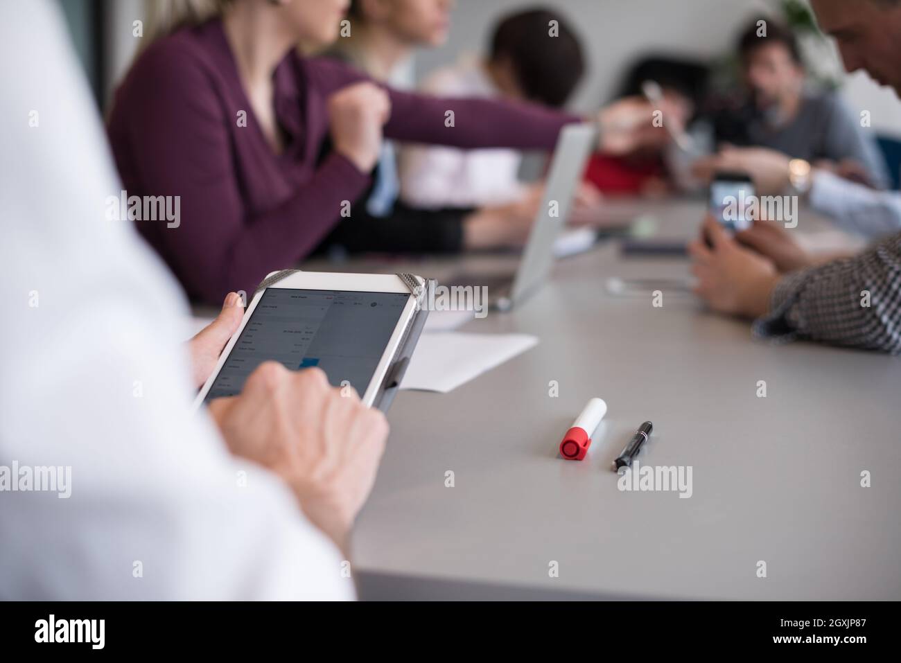 close up of businessman hands using tablet, people group in office ...