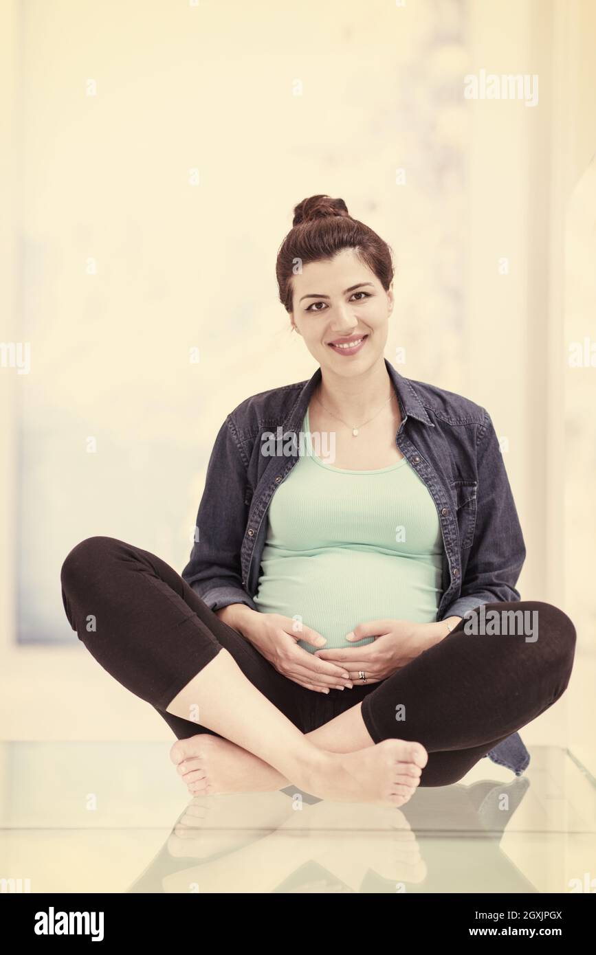 happy pregnant women enjoying pregnancy relaxing at home sitting on the ...