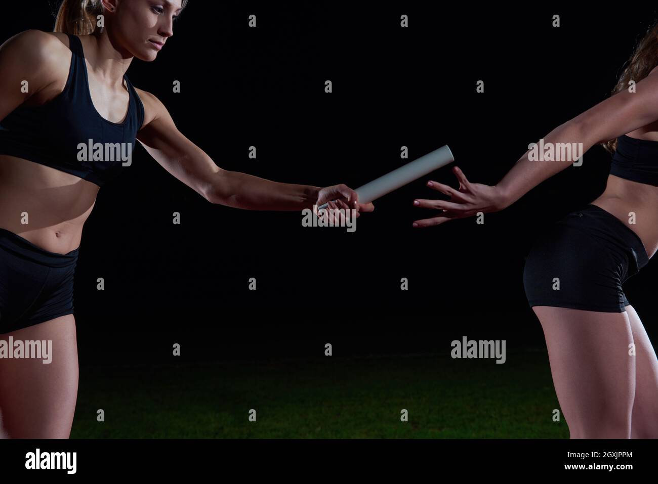 woman athletic runners passing baton in relay race Stock Photo - Alamy