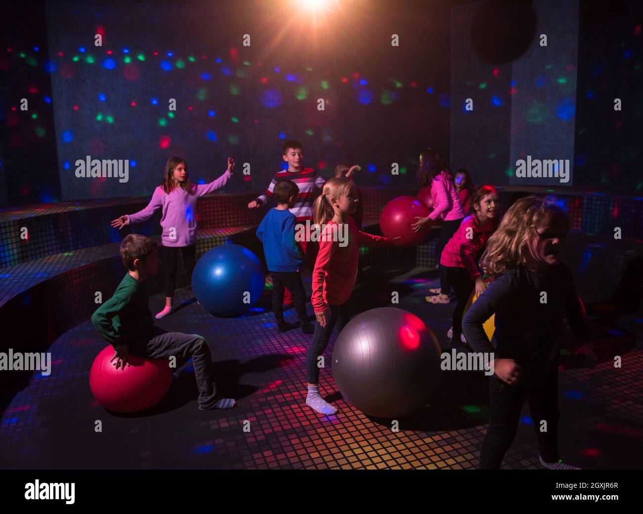A group of joyful children happily spending time at Kids neon disco ...