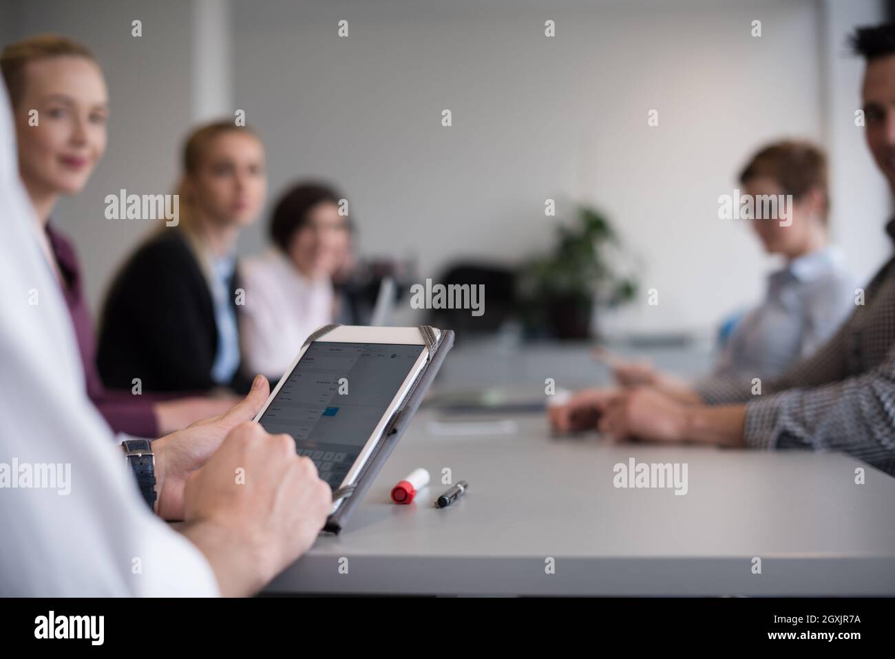 close up of businessman hands using tablet, people group in office ...