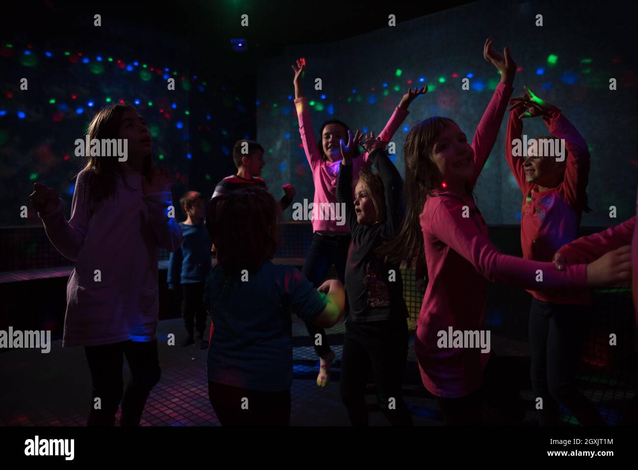 A group of joyful children happily spending time at Kids neon disco ...