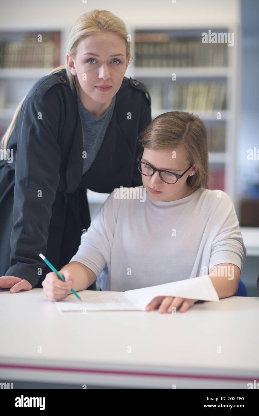 female teacher helping students on class about lessons and give support ...