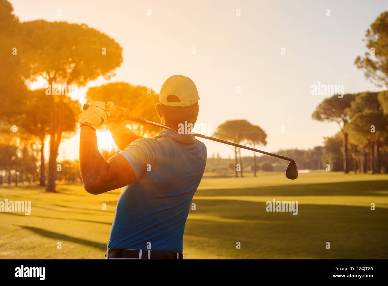 golf player hitting shot with club on course at beautiful morning with ...