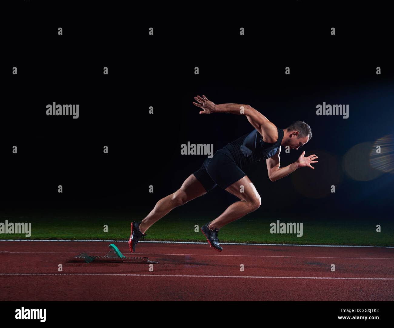 Sprinter leaving starting blocks on the running track. Explosive start ...