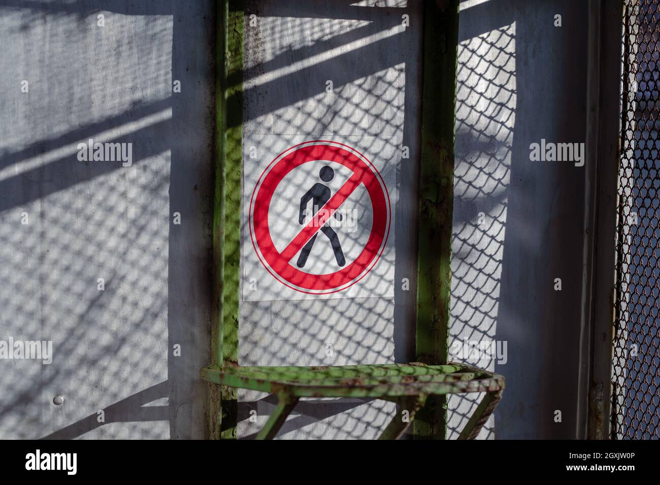 A sign prohibiting access to the fence. Gray fence with a red and white ...