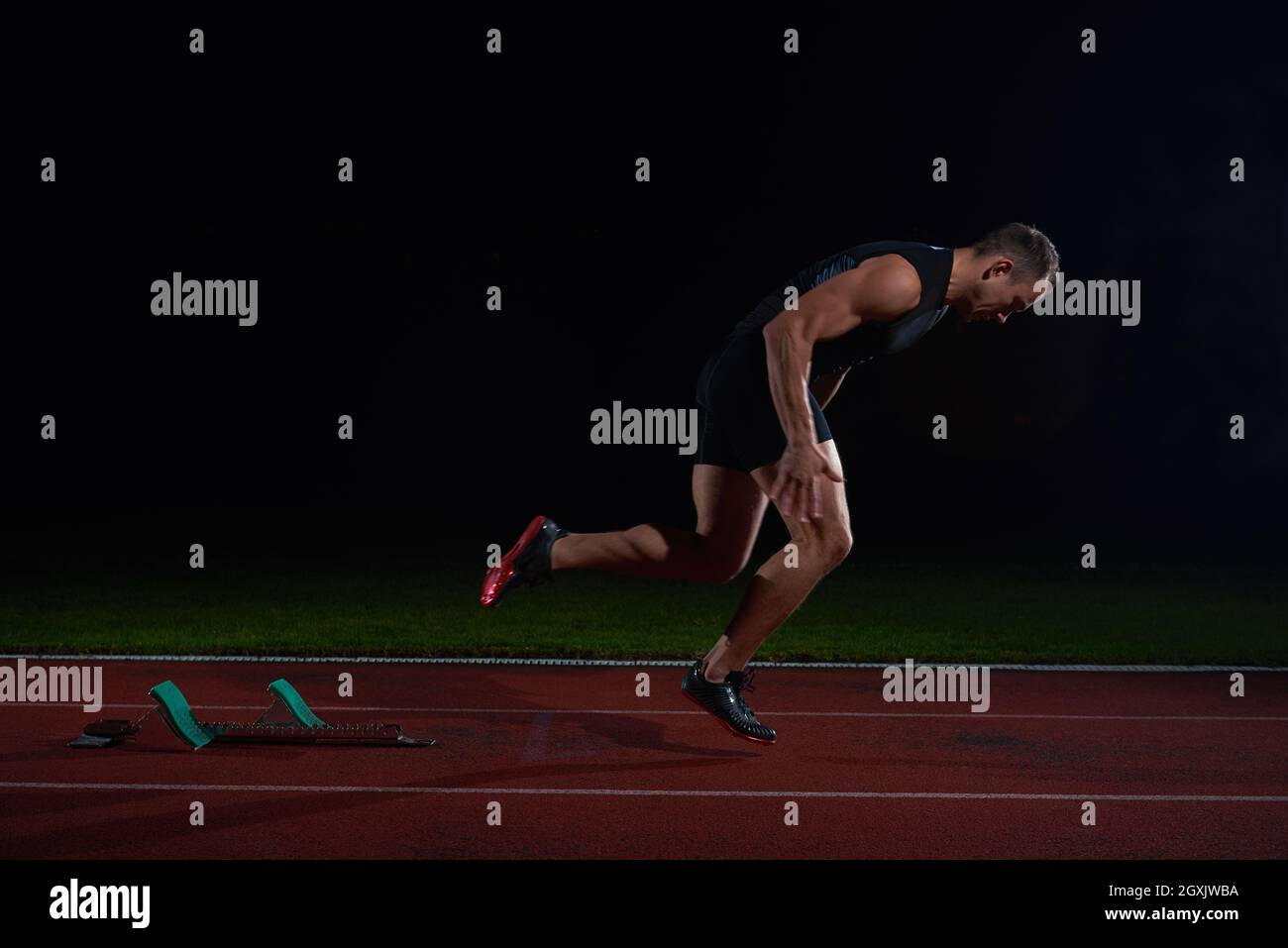 Sprinter leaving starting blocks on the running track. Explosive start ...