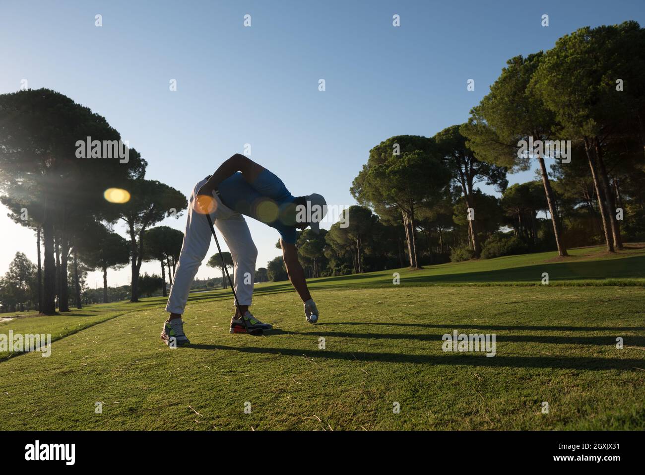 golf player hitting shot with club on course at beautiful morning with ...