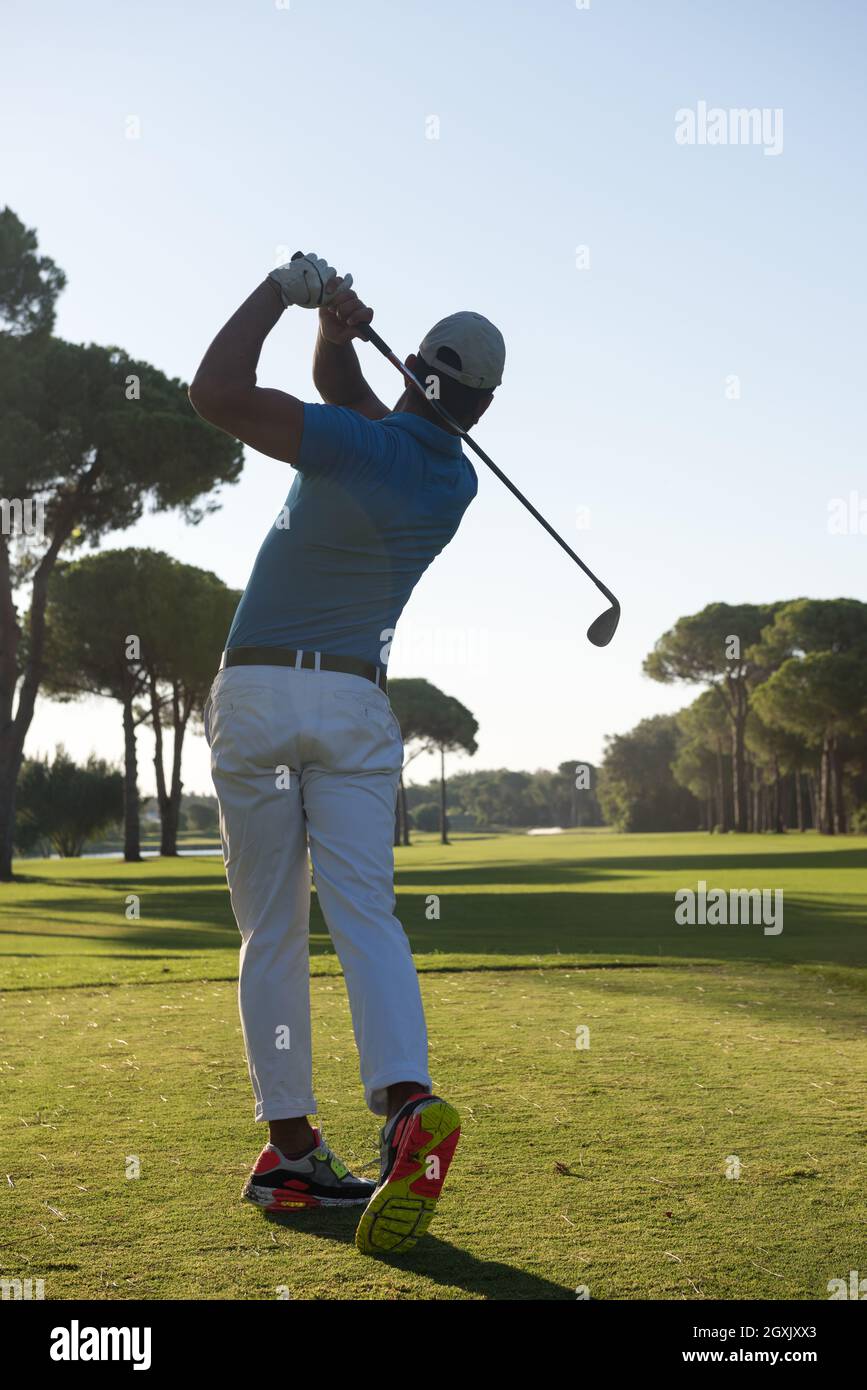 golf player hitting shot with club on course at beautiful morning with ...