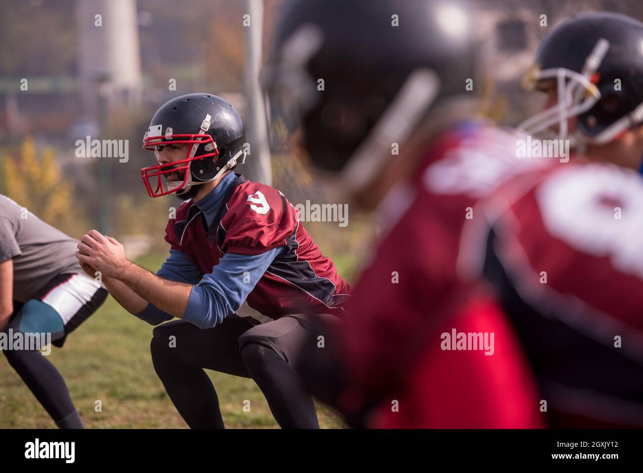 group of young american football players stretching and warming up ...
