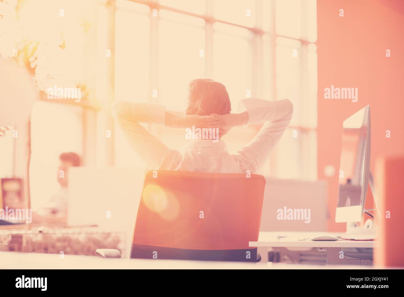 Happy young business woman relaxing and geting insiration while working ...