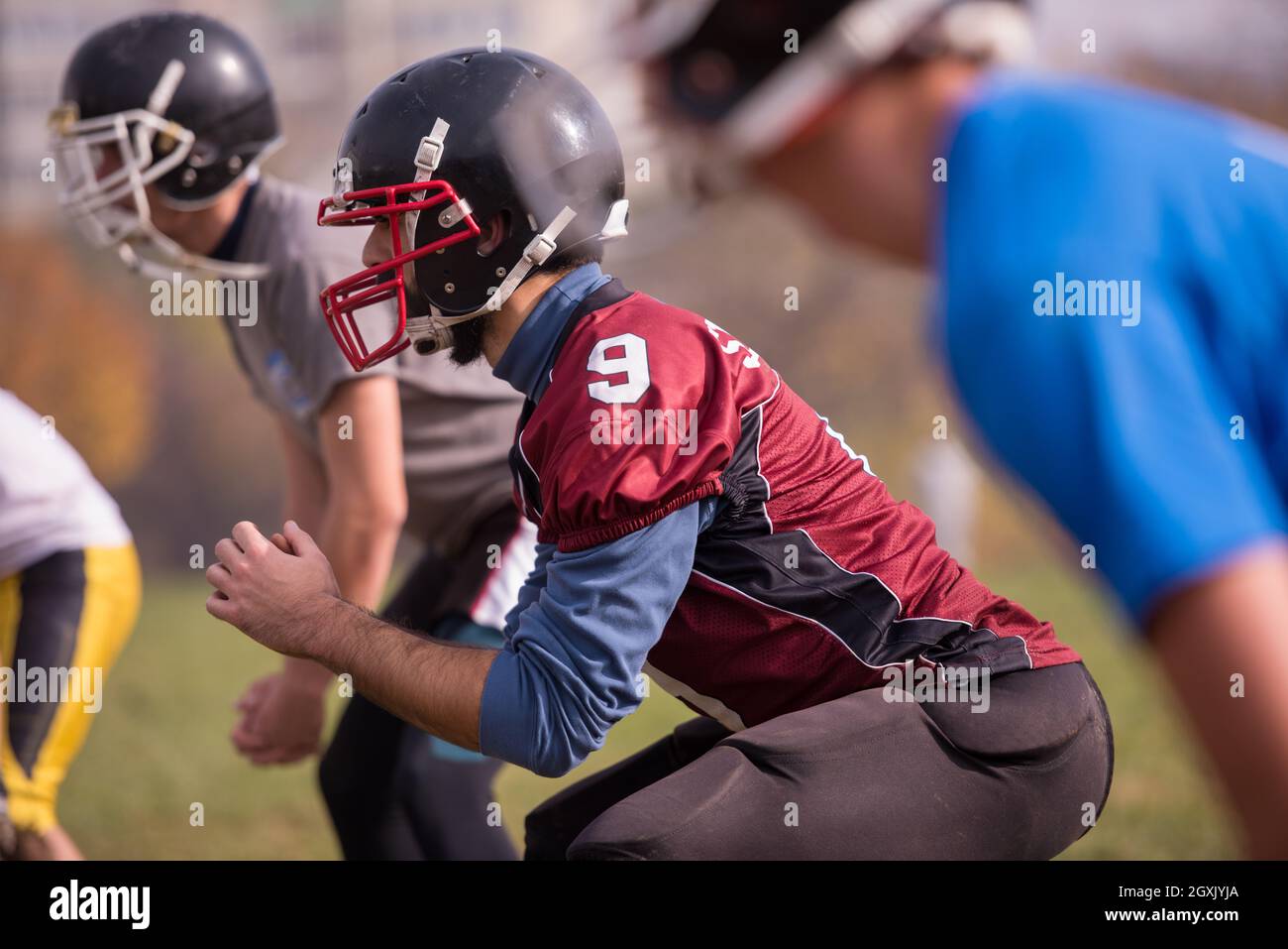 group of young american football players stretching and warming up ...
