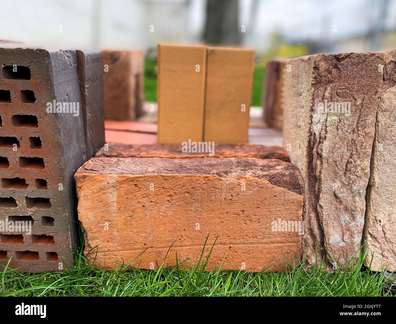 Different types of bricks stacked beautifully on green grass Stock ...