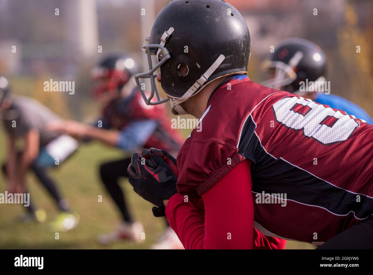group of young american football players stretching and warming up ...
