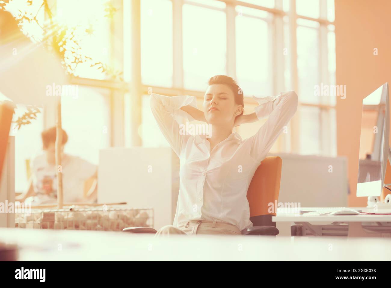 Happy young business woman relaxing and geting insiration while working ...