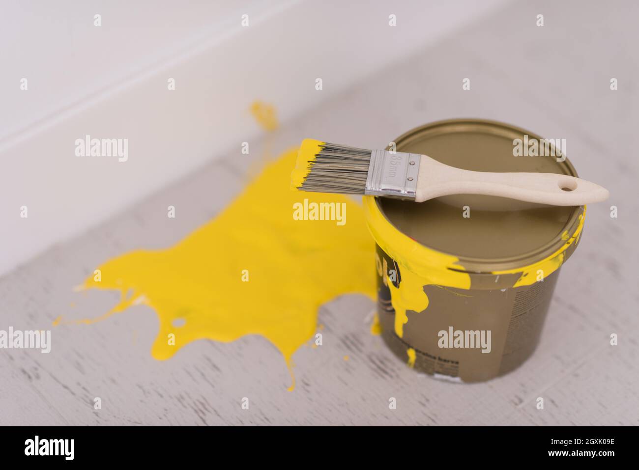 Yellow paint tin can with brush on top with yellow strokes on the ...