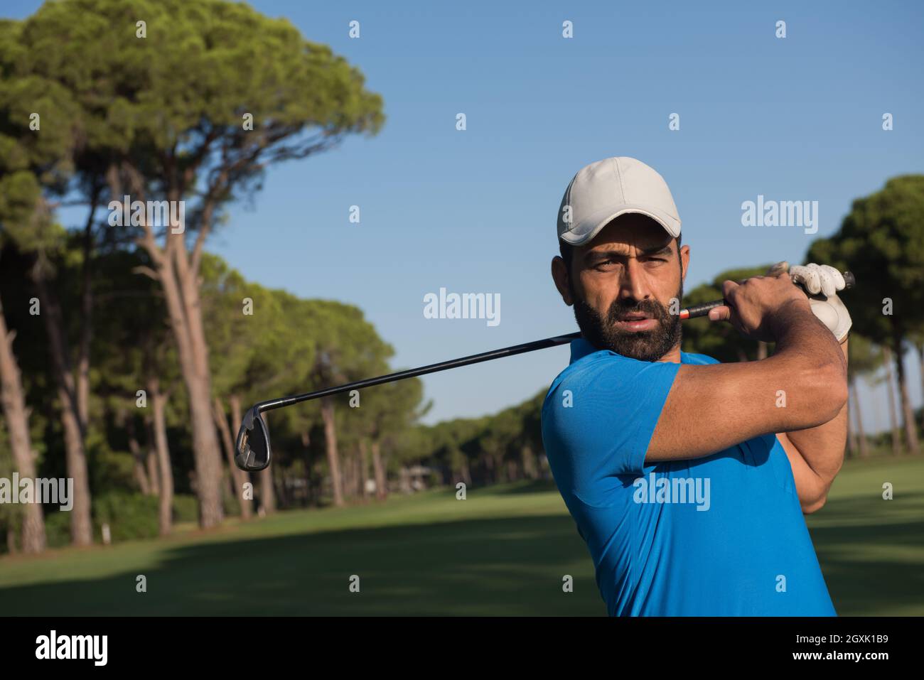 golf player hitting shot with club on course at beautiful morning with ...