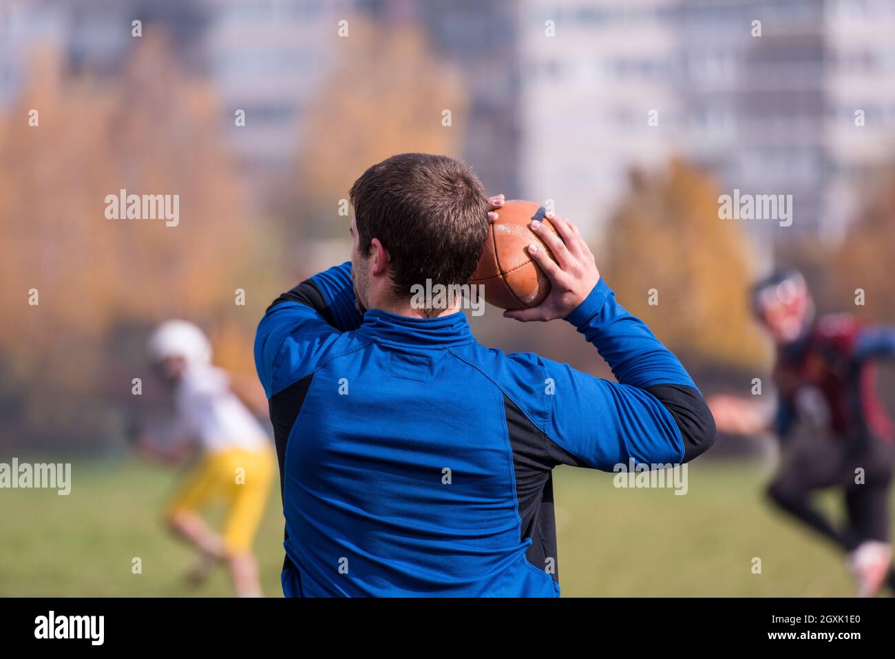 Team coach throwing the ball into the group of young american football ...