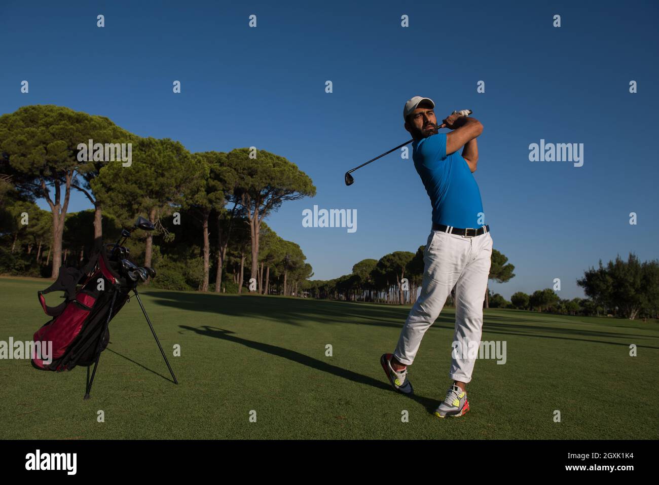 golf player hitting shot with club on course at beautiful morning with ...