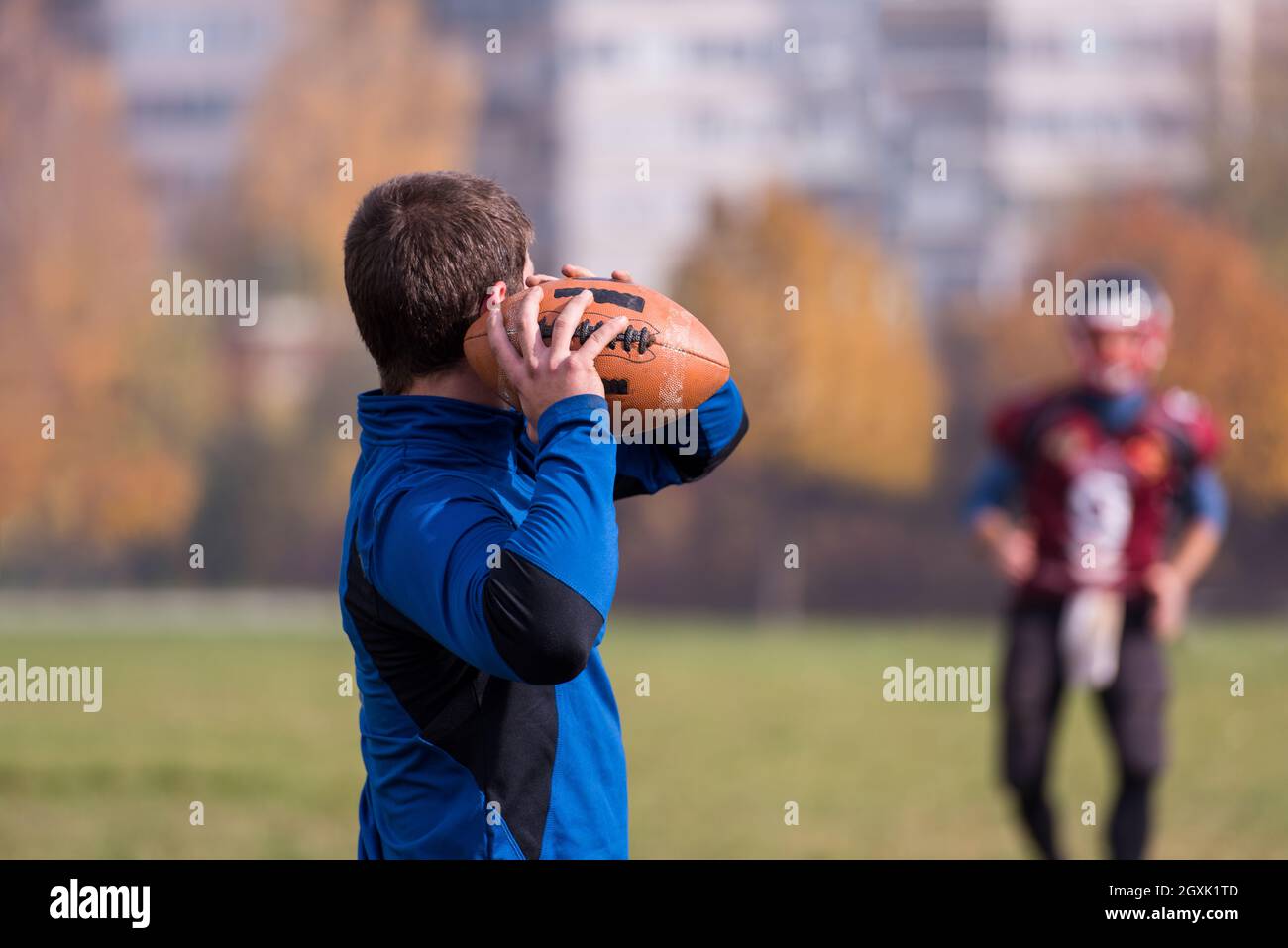 Team coach throwing the ball into the group of young american football ...