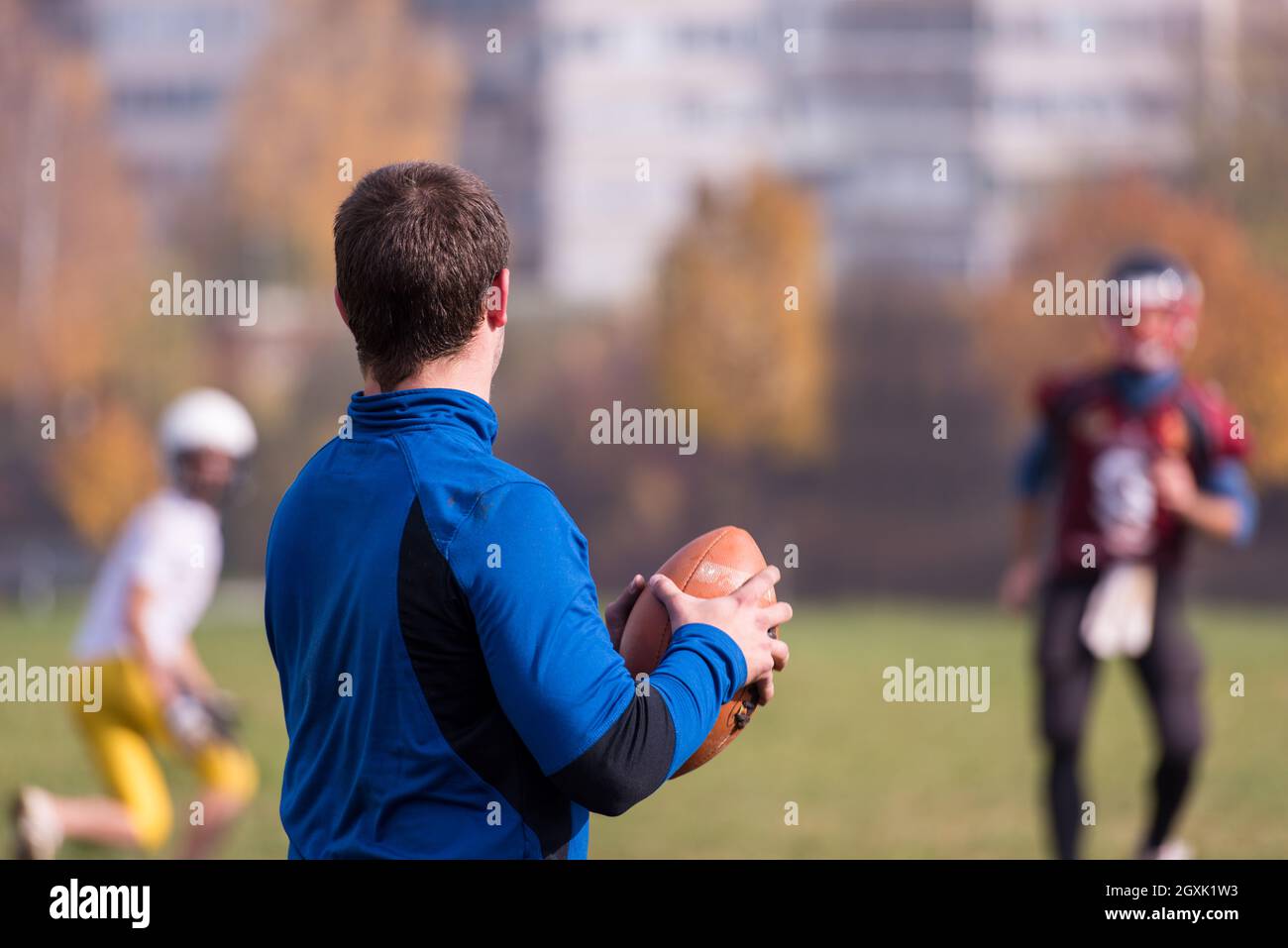 Team coach throwing the ball into the group of young american football ...