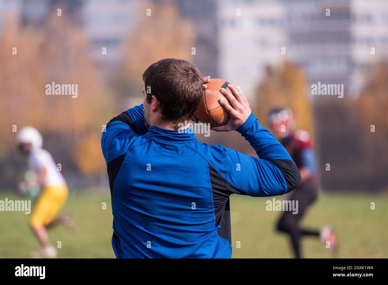 Team coach throwing the ball into the group of young american football ...