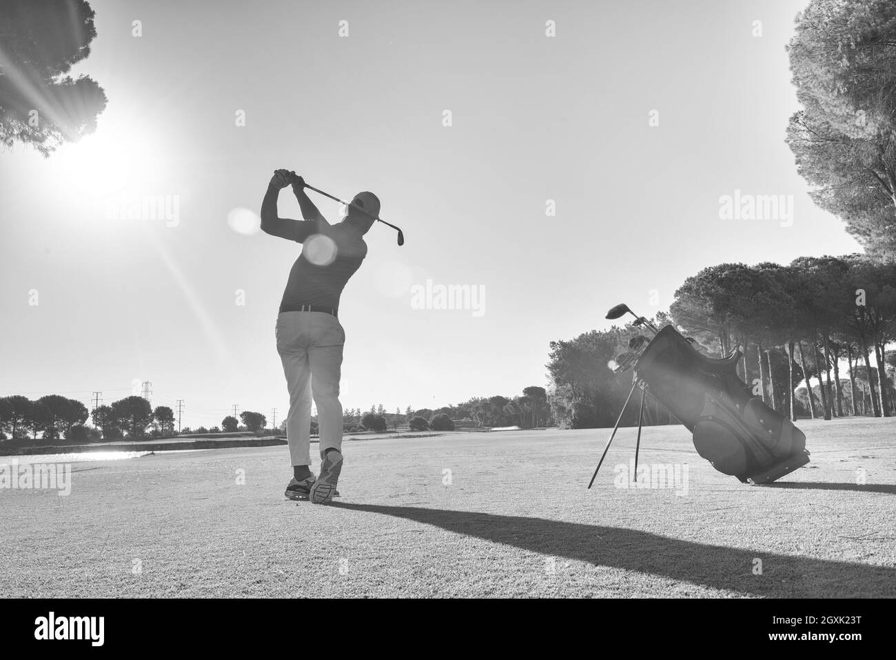 golf player hitting shot with club on course at beautiful morning black ...