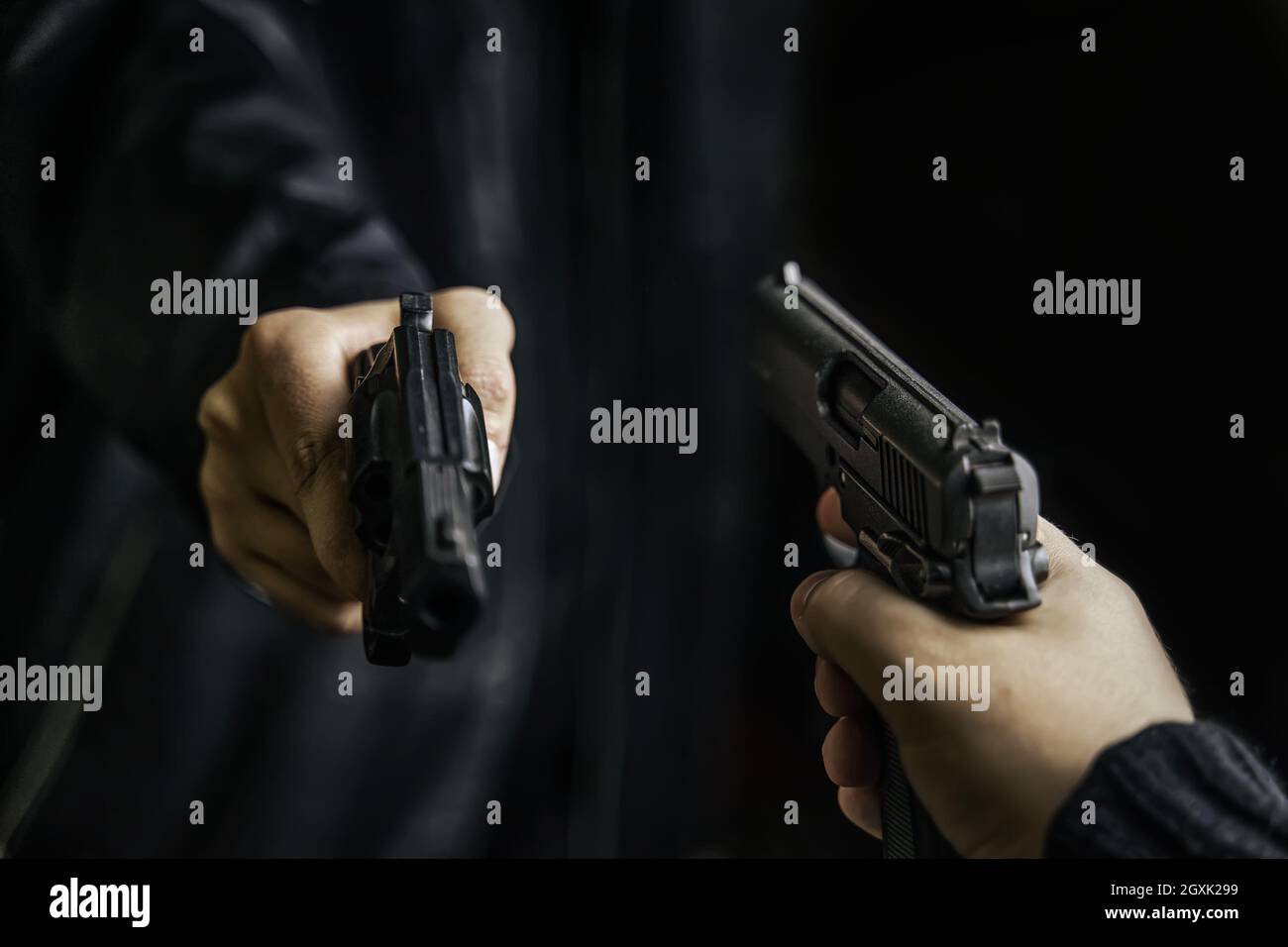 Two person's hands with weapons pointed at each other. Shootout with ...